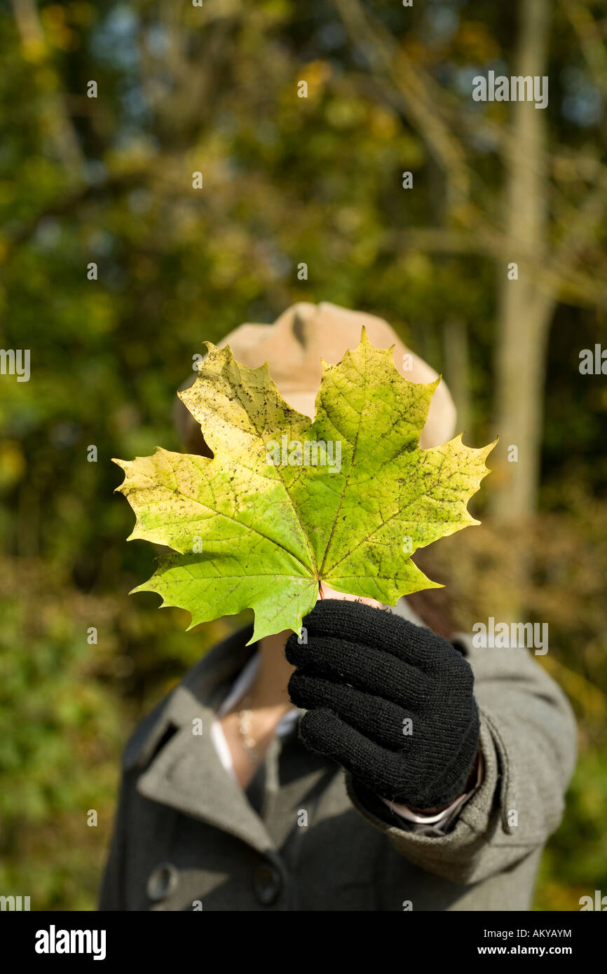 Girl holding an autumn leaf in front of her face Stock Photo - Alamy