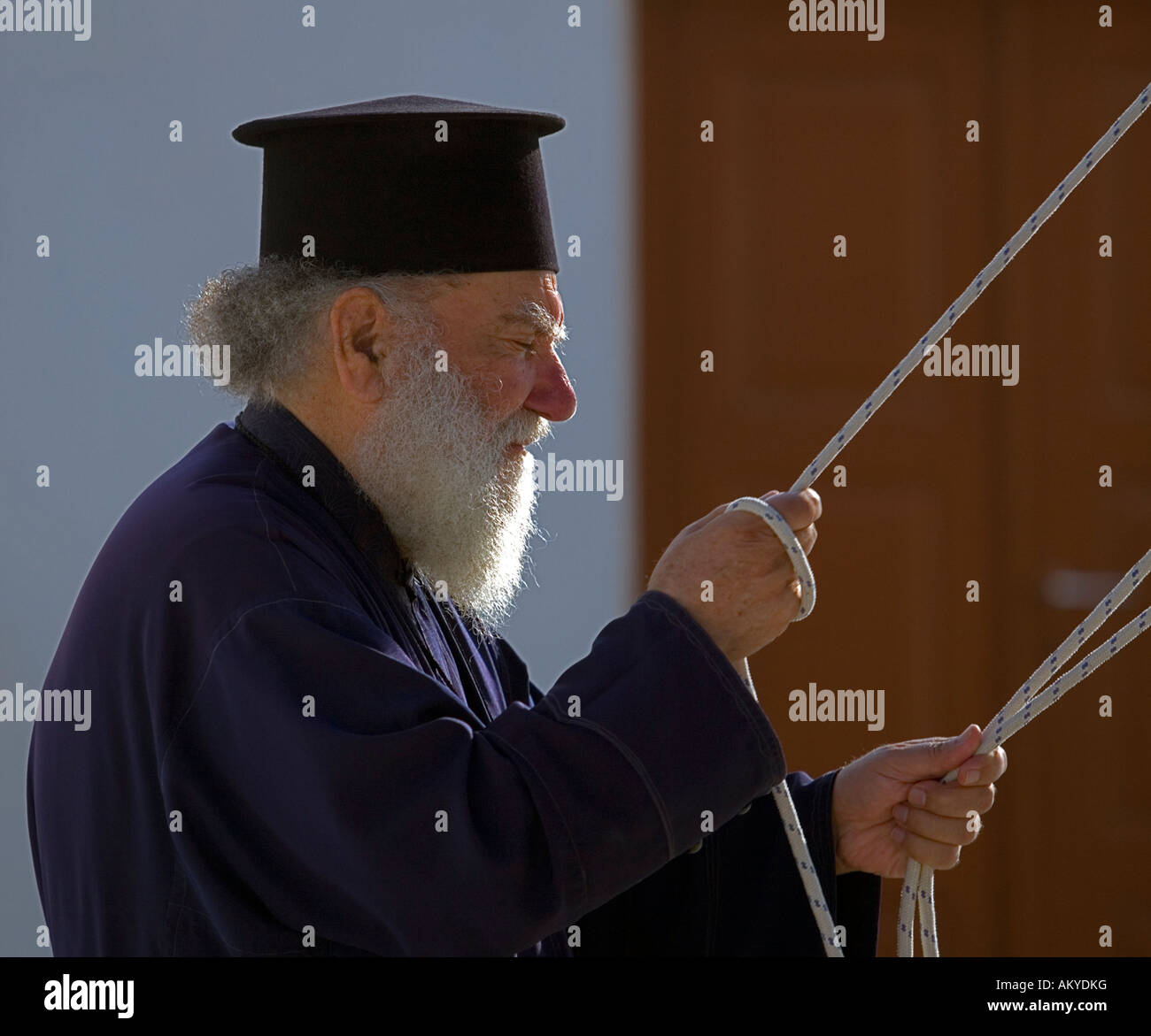 Priest sounds evening church bell Oia Santorini Greece Stock Photo - Alamy
