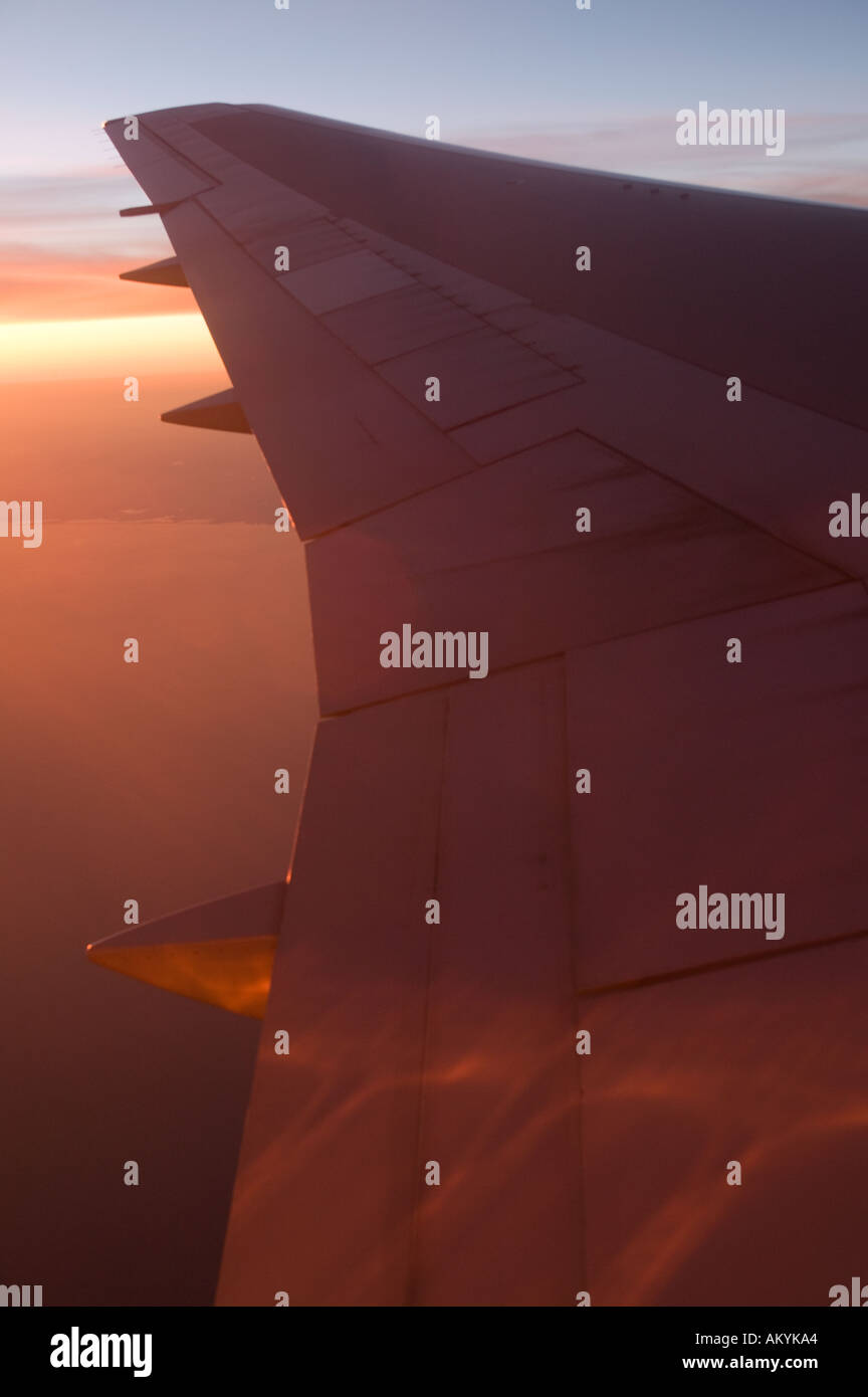 Wing of an airplane with clouds at sunset hi-res stock photography and ...