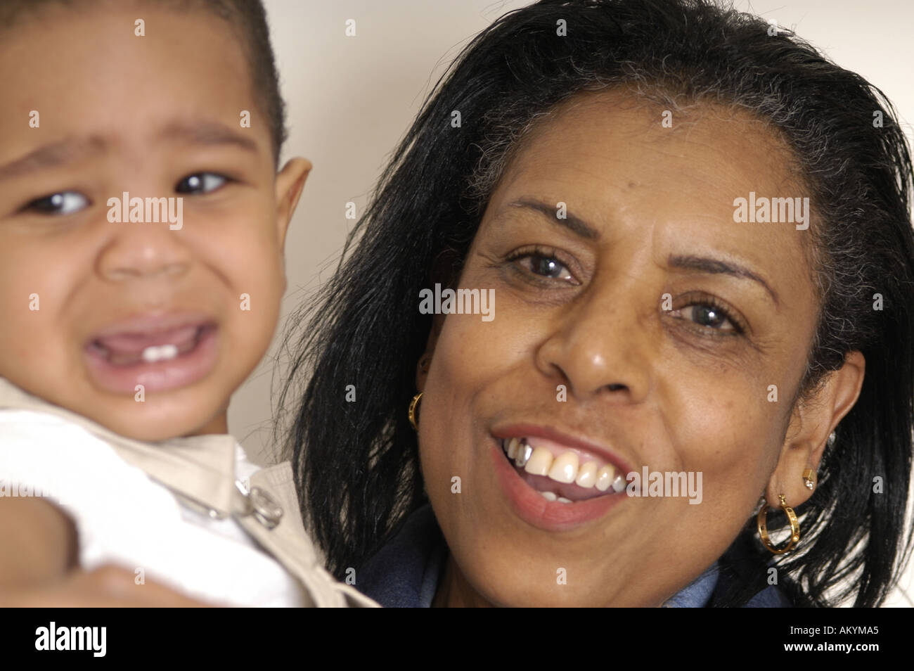 mother and child baby crying soothe cuddle hug smiling Stock Photo - Alamy