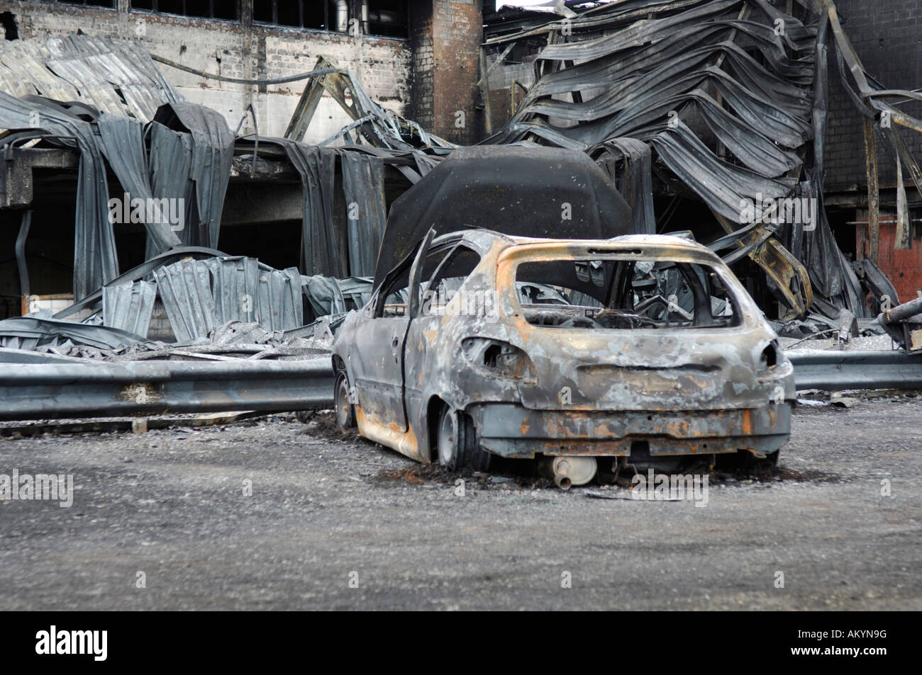 Burnt down car in front of an factory building Stock Photo - Alamy