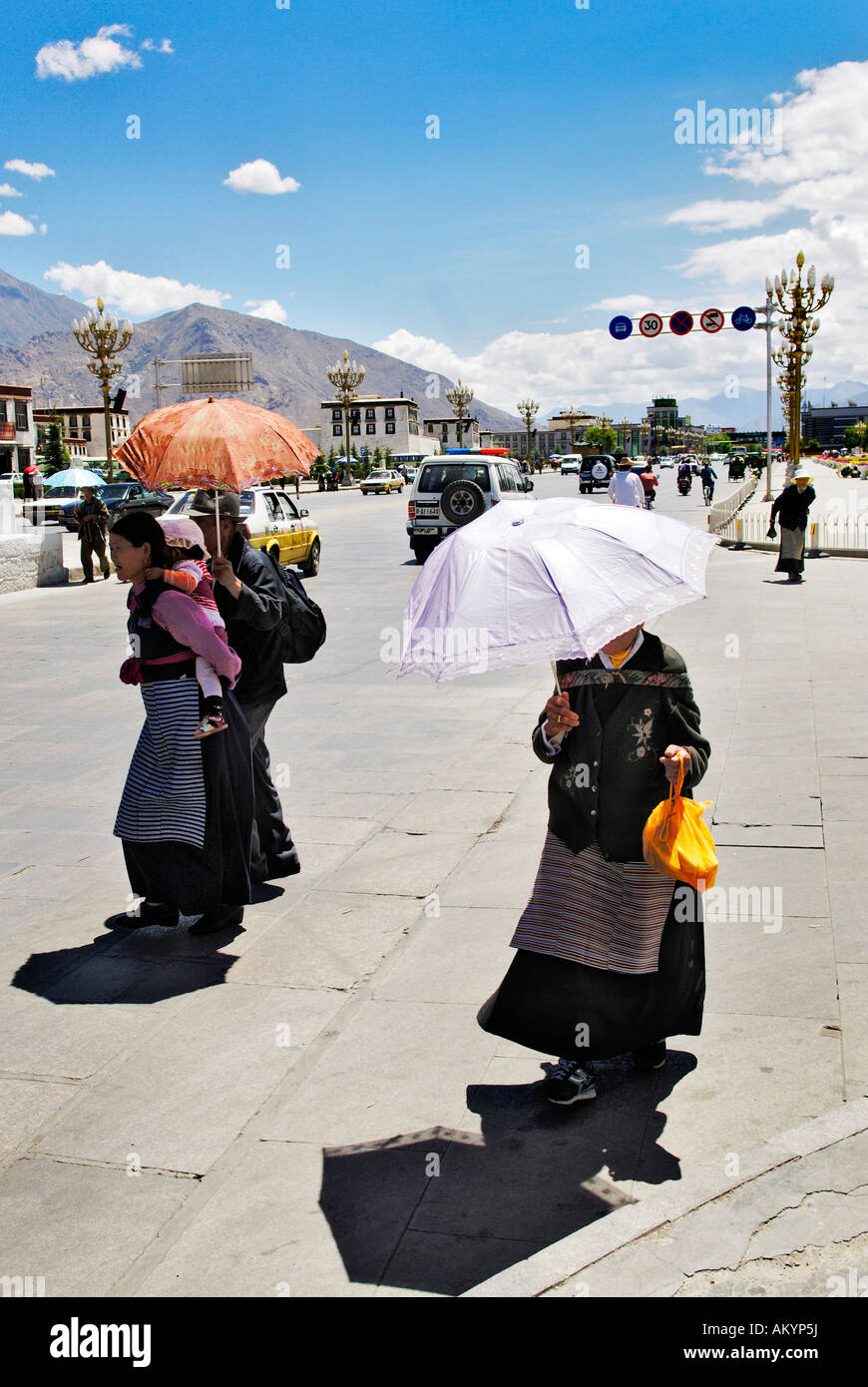 Tibetan women with sun parasol cross the street, Lhasa, Tibet Stock ...