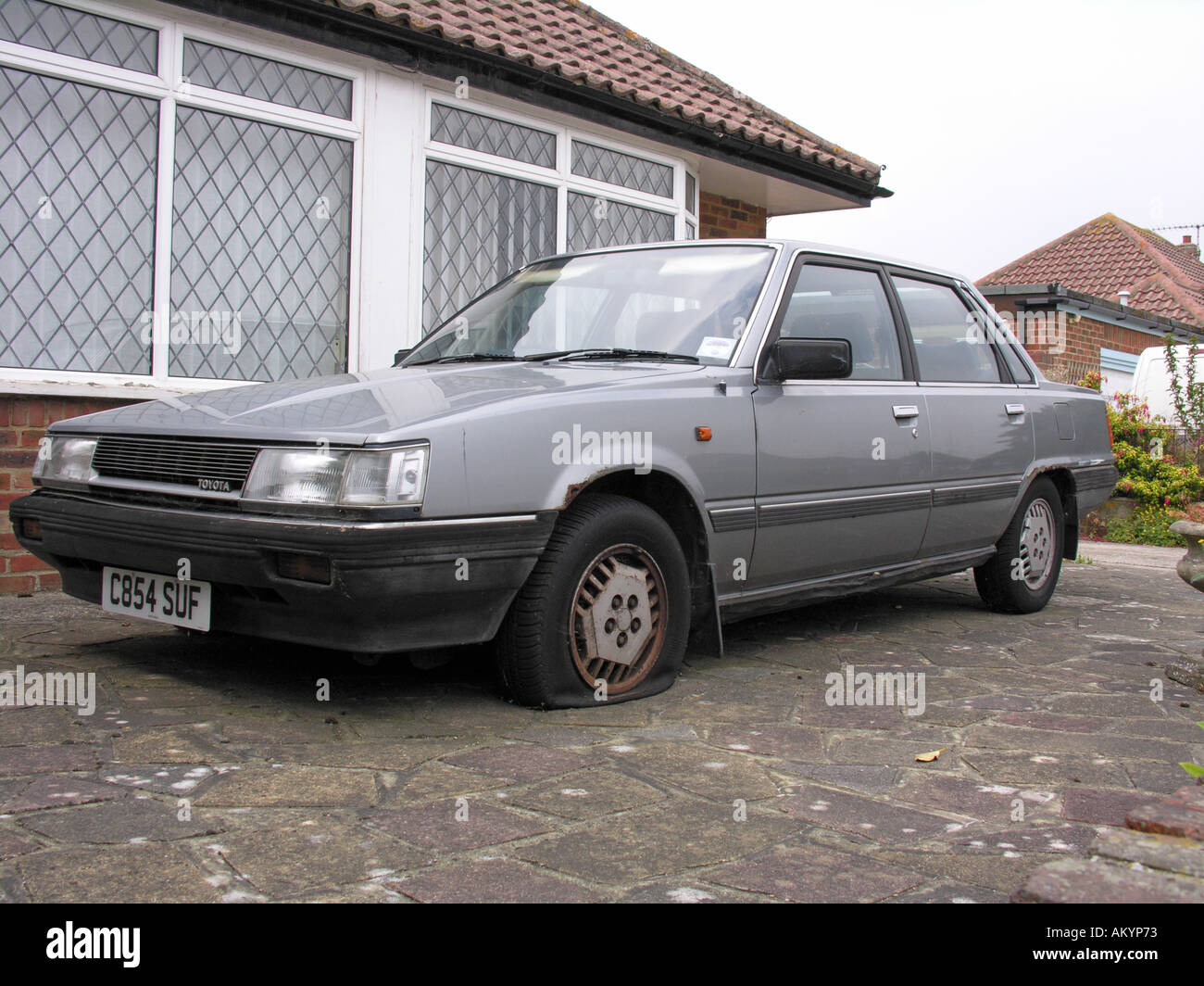 scrap dumped old car in front of residential property off road with ...