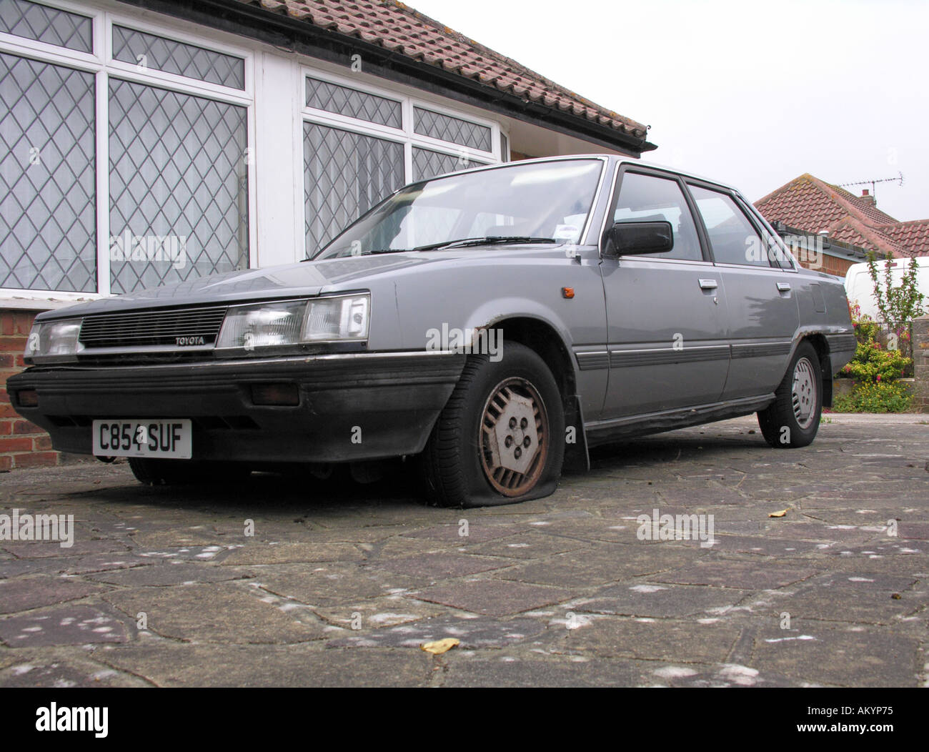 scrap dumped old car in front of residential property off road with ...