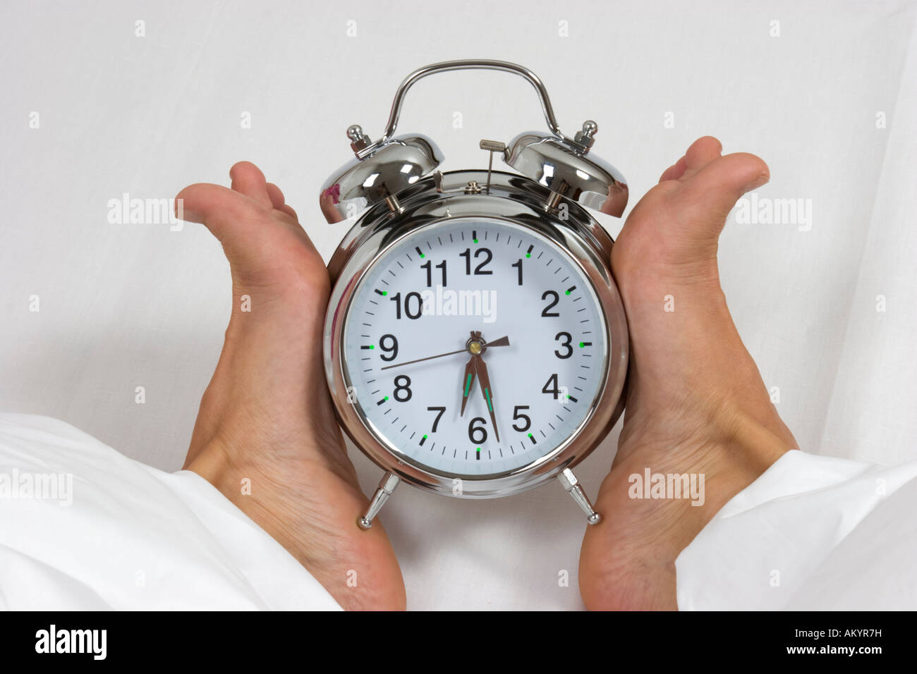 Blanket, feet, alarm clock Stock Photo - Alamy