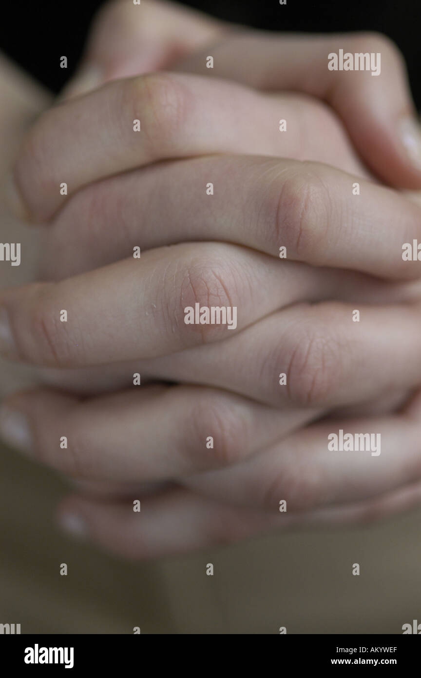 Folded hands resting on a lap Stock Photo - Alamy