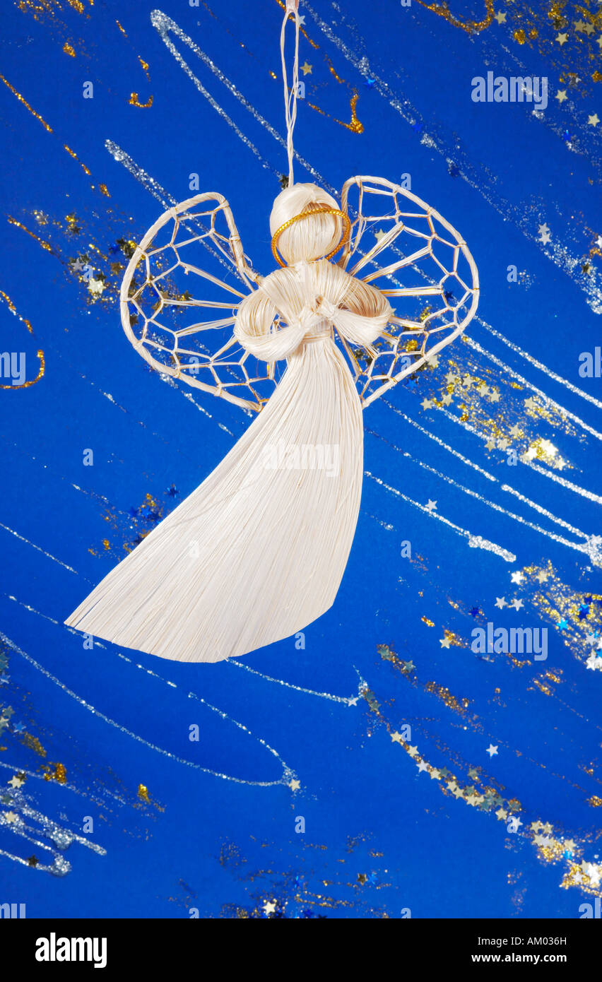 Festive Christmas wicker angel figure on blue decorative winter ...