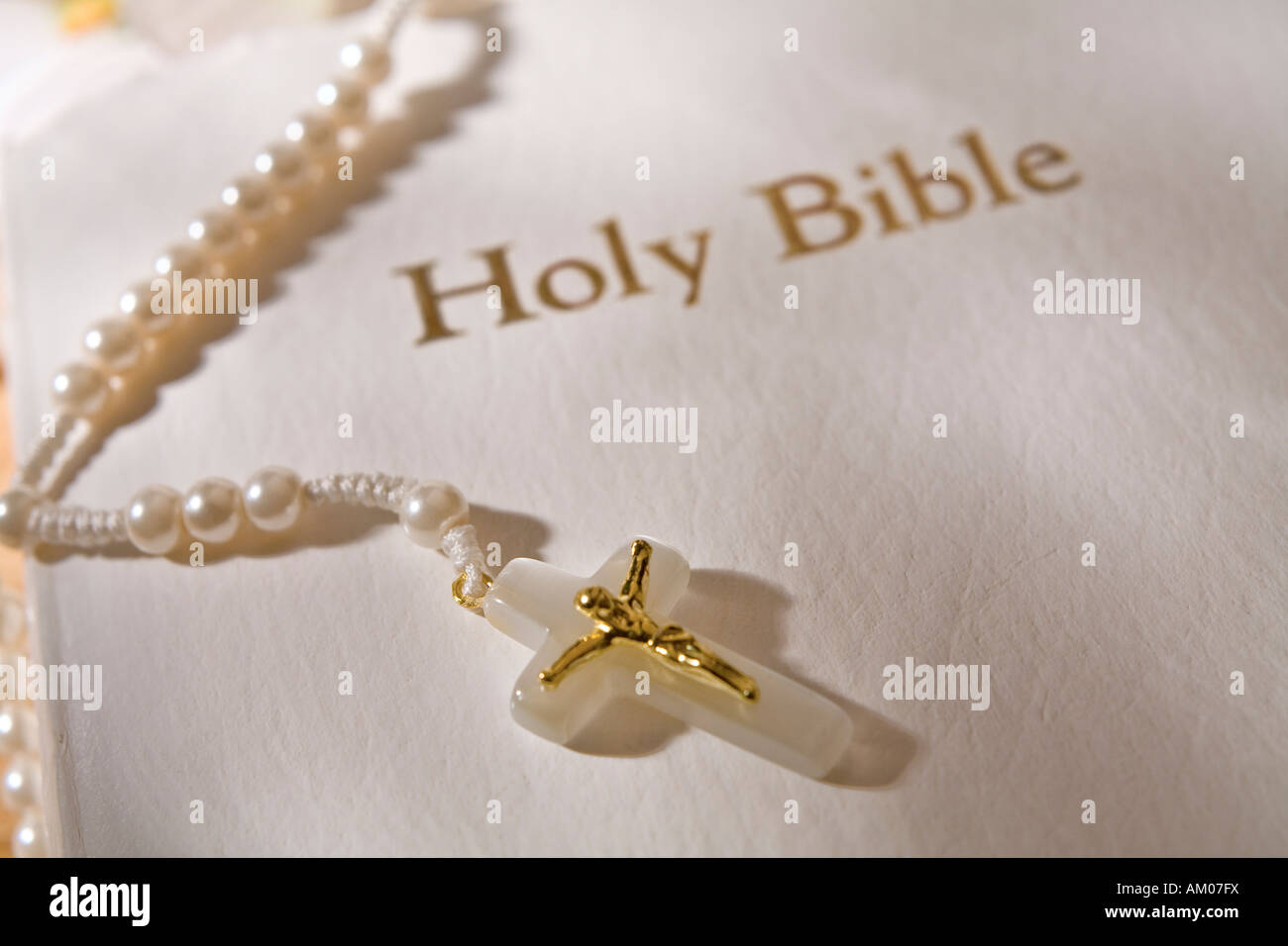 Rosary beads laying across a white Bible Stock Photo - Alamy