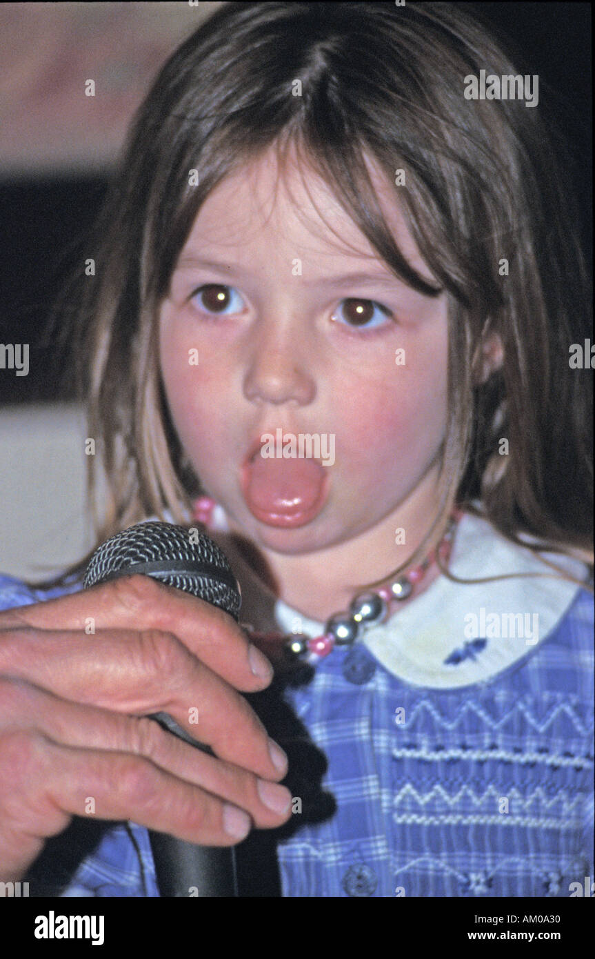 young girl talking singing into microphone Stock Photo - Alamy