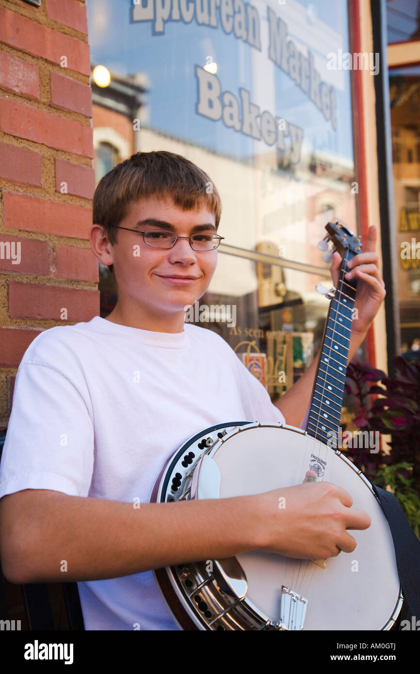 ILLINOIS Galena Teenage boy play banjo outside store on Main Street ...