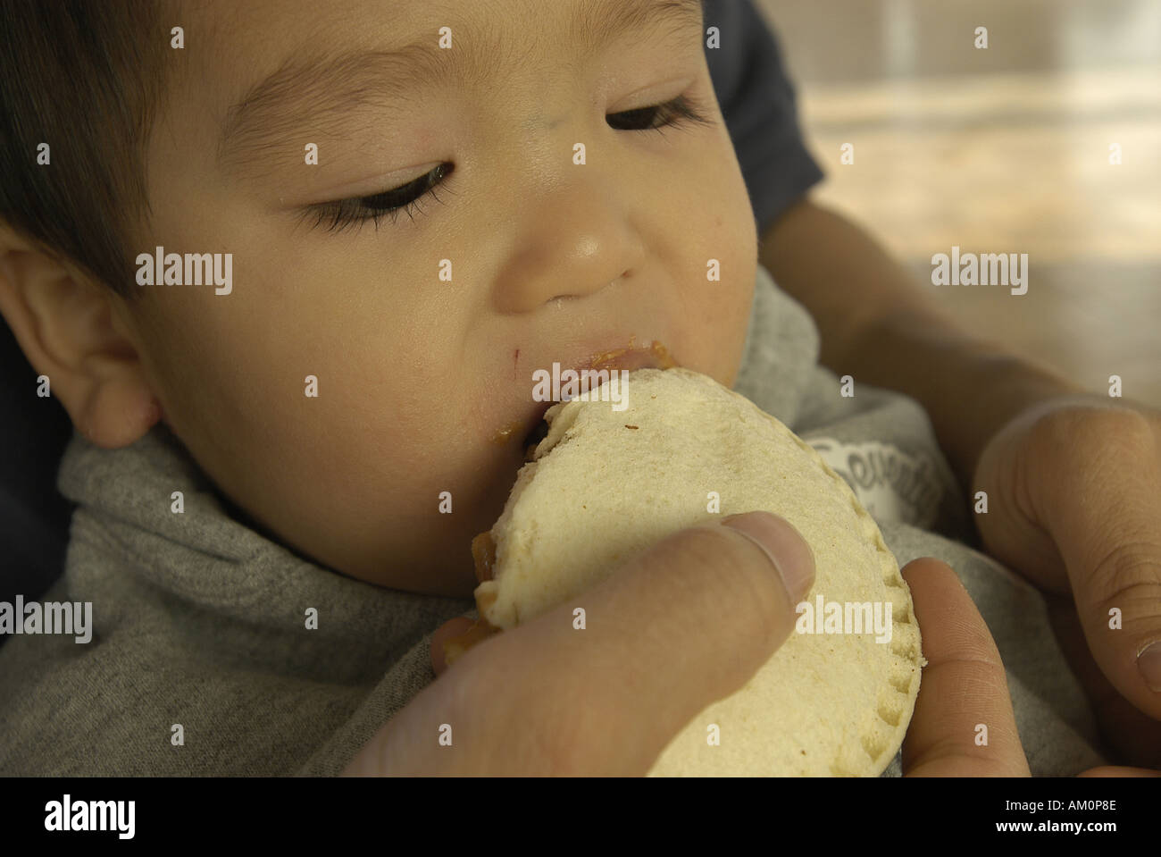 Child infant baby Asian Chinese face feed eat lunch snack chew bite ...