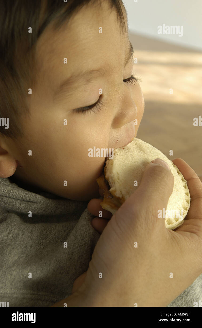 Child infant baby Asian Chinese face feed eat lunch snack chew bite ...