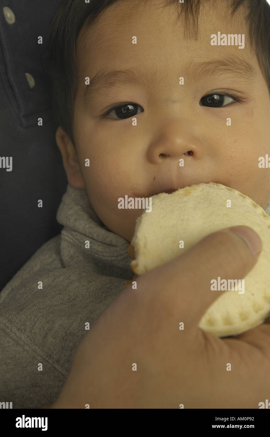 Child infant baby Asian Chinese face feed eat lunch snack chew bite ...