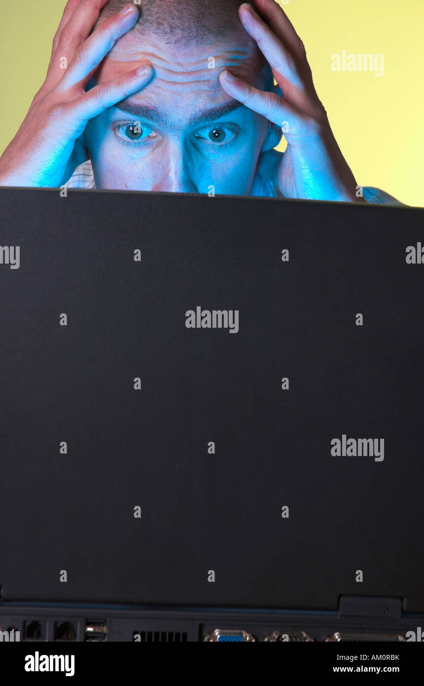 Computer user having a bad day with tech problems online. His face ...