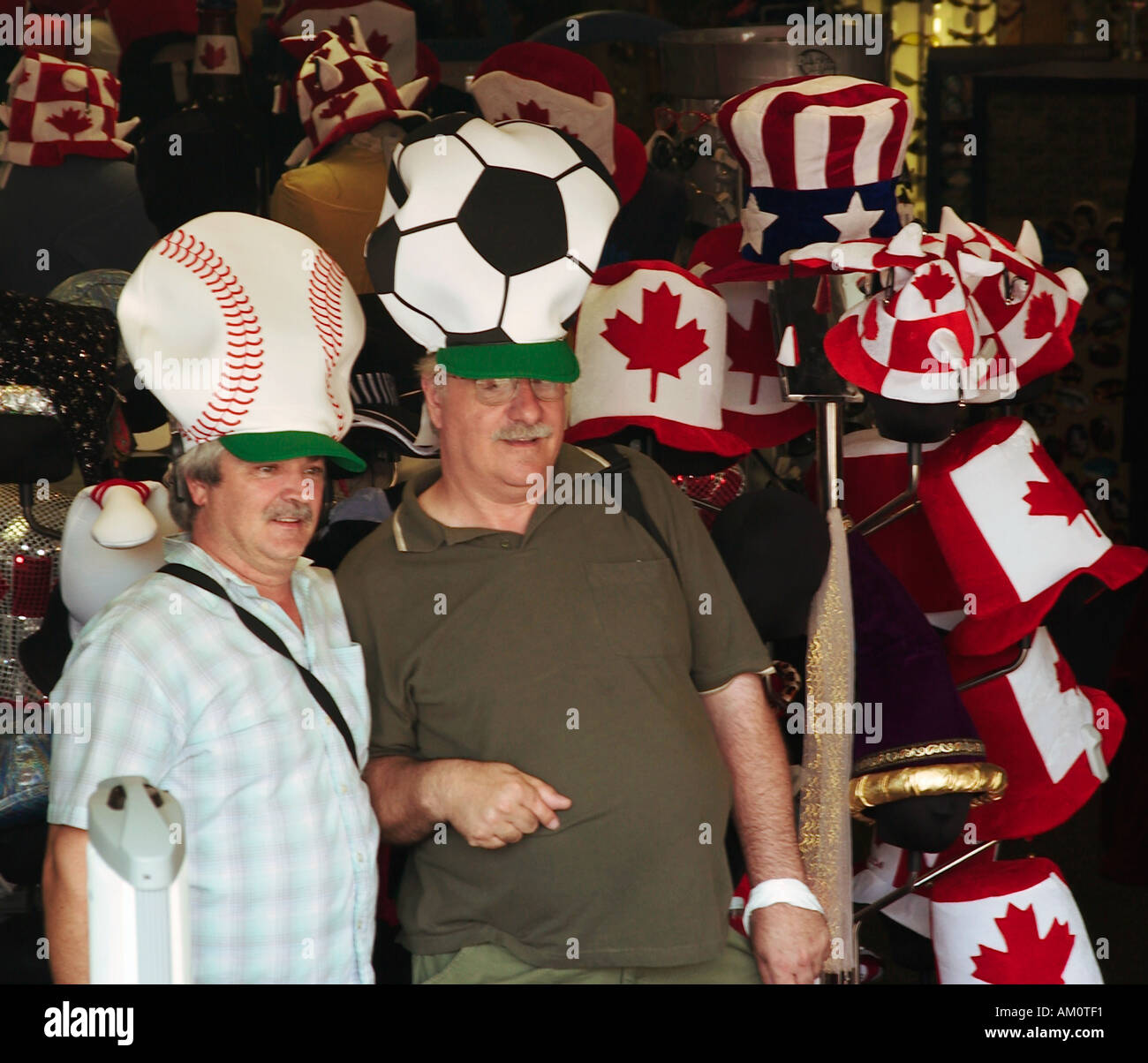 Two men having fun trying on a variety of funny hats at Niagara Falls ...