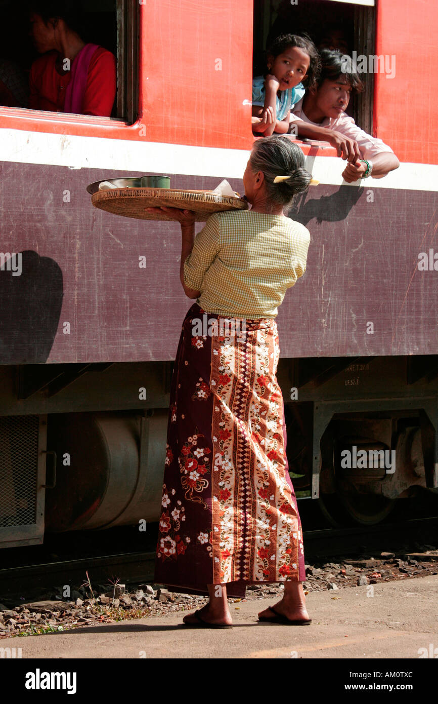 Food vendor selling to train passengers at the railway station at Kalaw ...