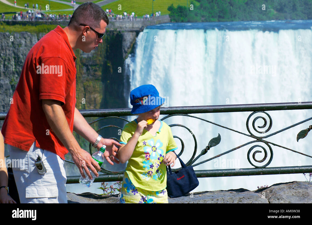 A father watches with delight as his child enjoys a colorful Popsicle ...