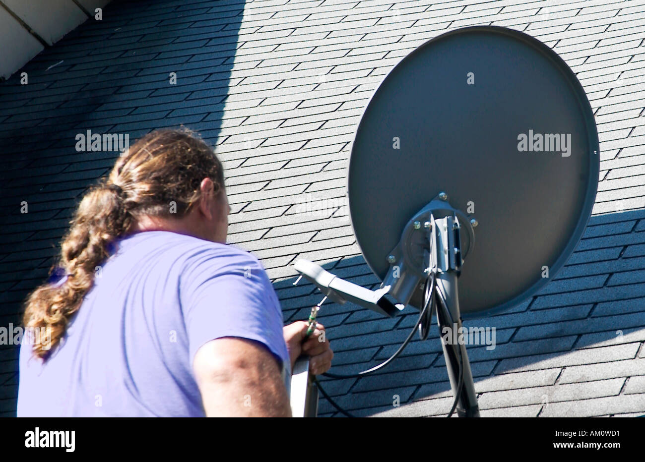 Technician installs tv satellite dish on roof hi-res stock photography ...