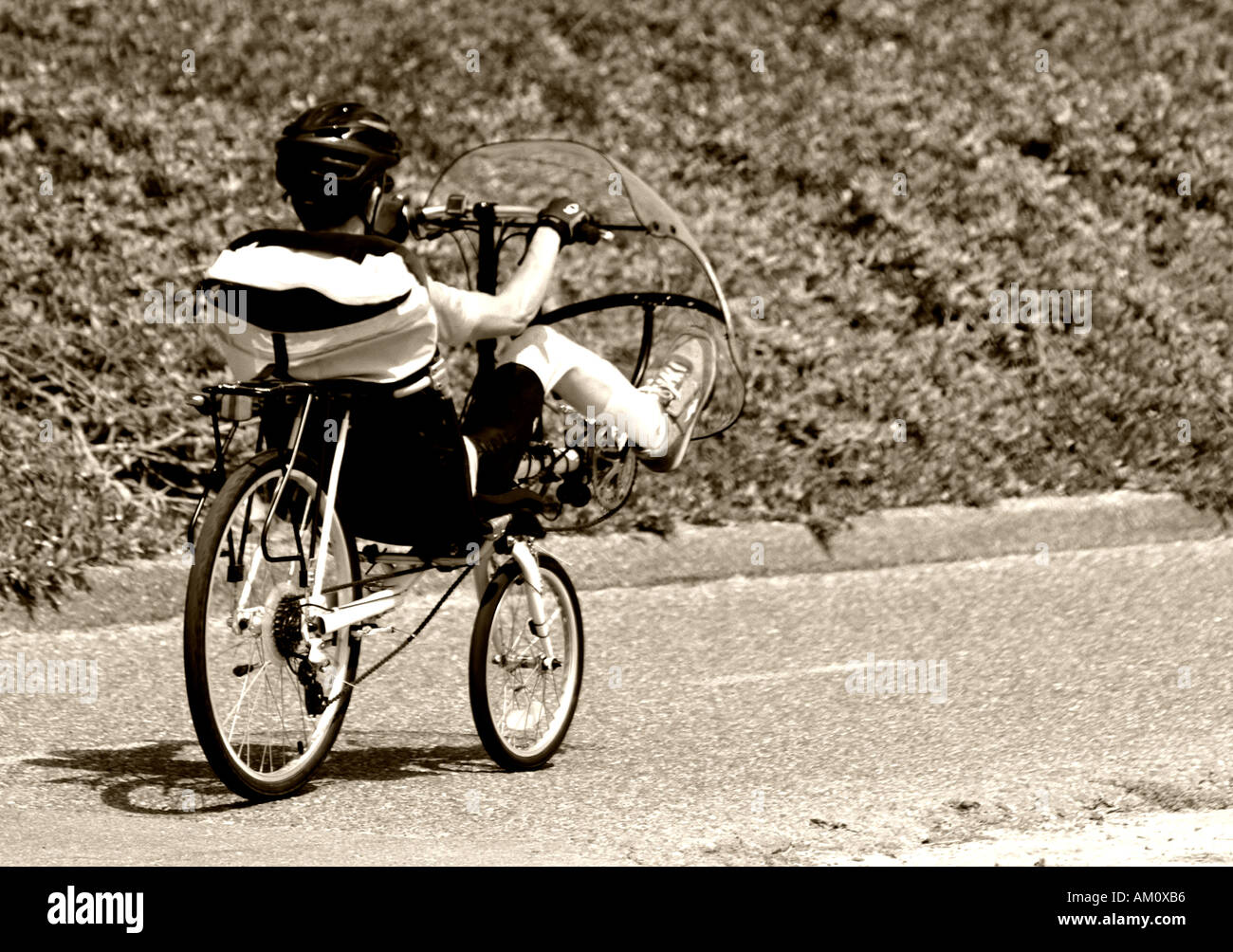 Man riding a unique bike with a windshield Stock Photo - Alamy