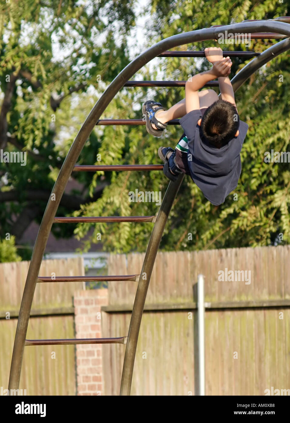 Boy climbing the monkey bars Stock Photo - Alamy