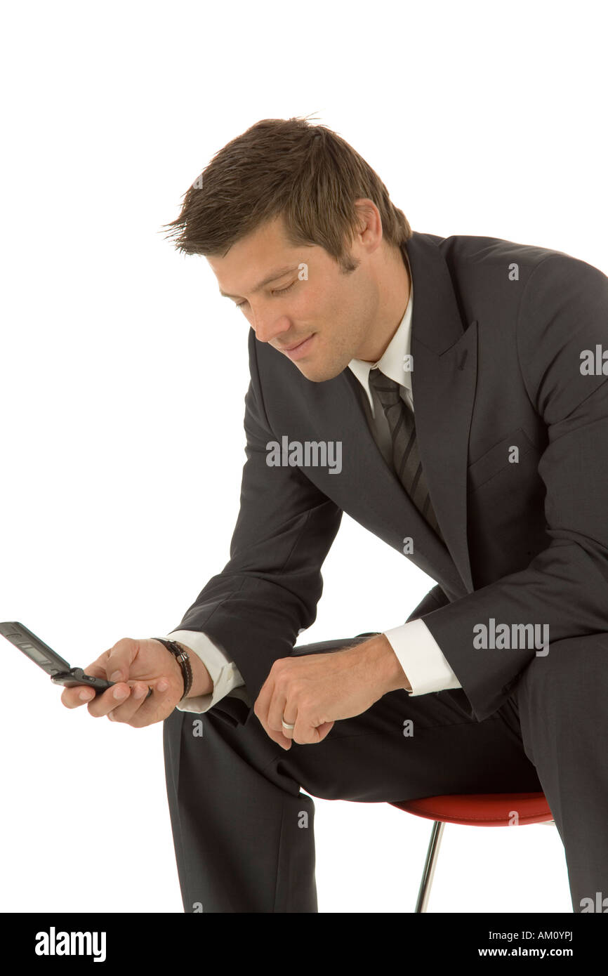 Young man in an office setting with a mobile phone against a white ...