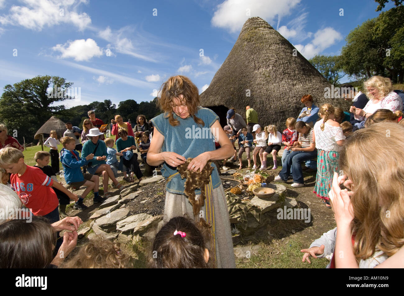 Woman demonstrating old method of spinning wool Castell henllys ...