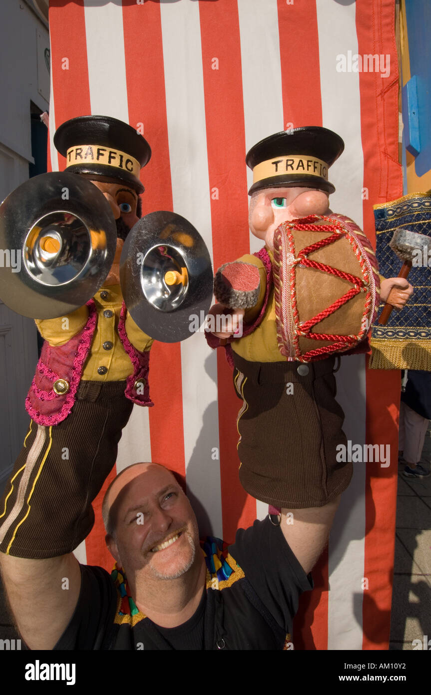 A puppeteer holding up two puppets in the guise of music playing ...