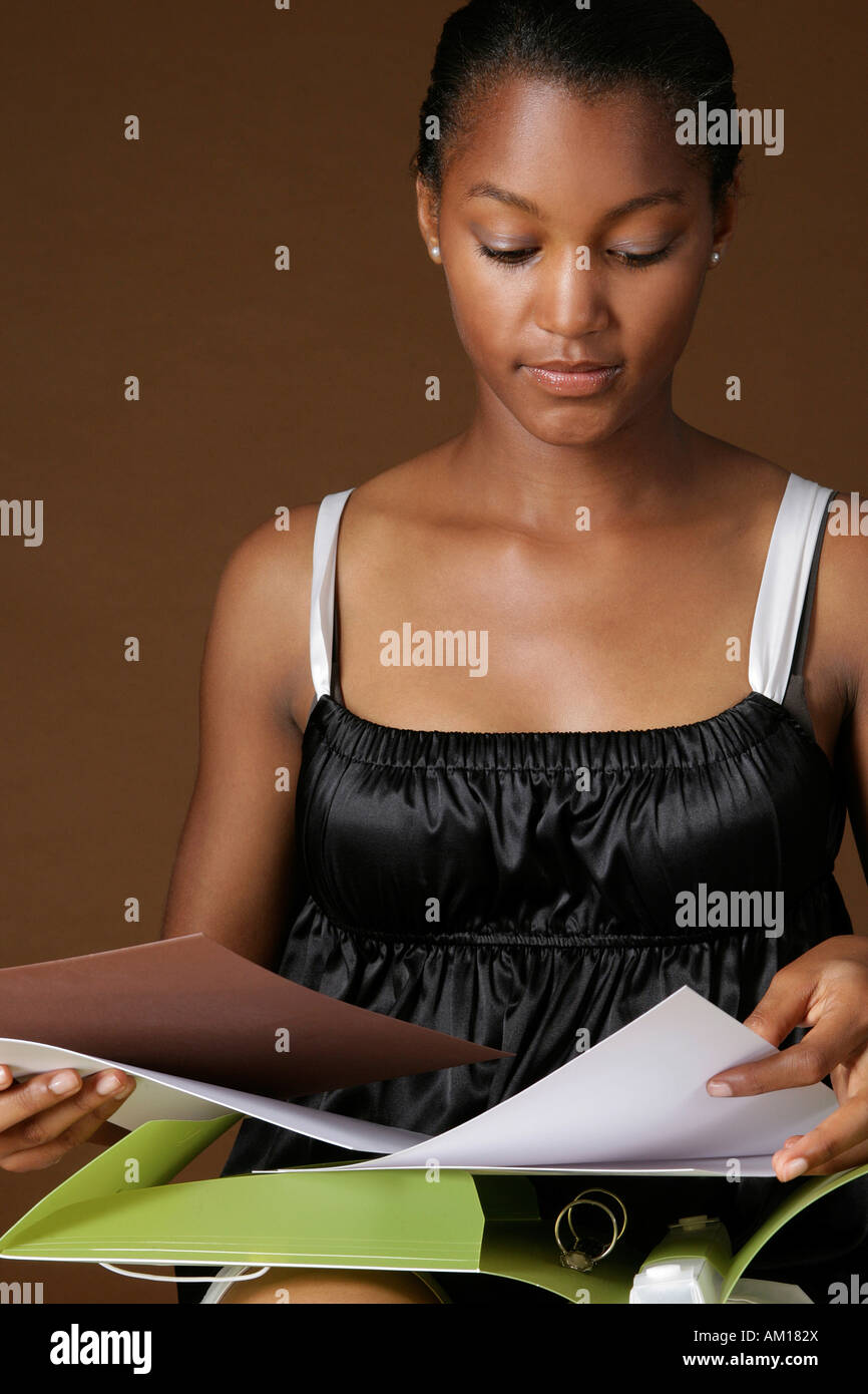Young dark-skinned woman flicking through files Stock Photo - Alamy