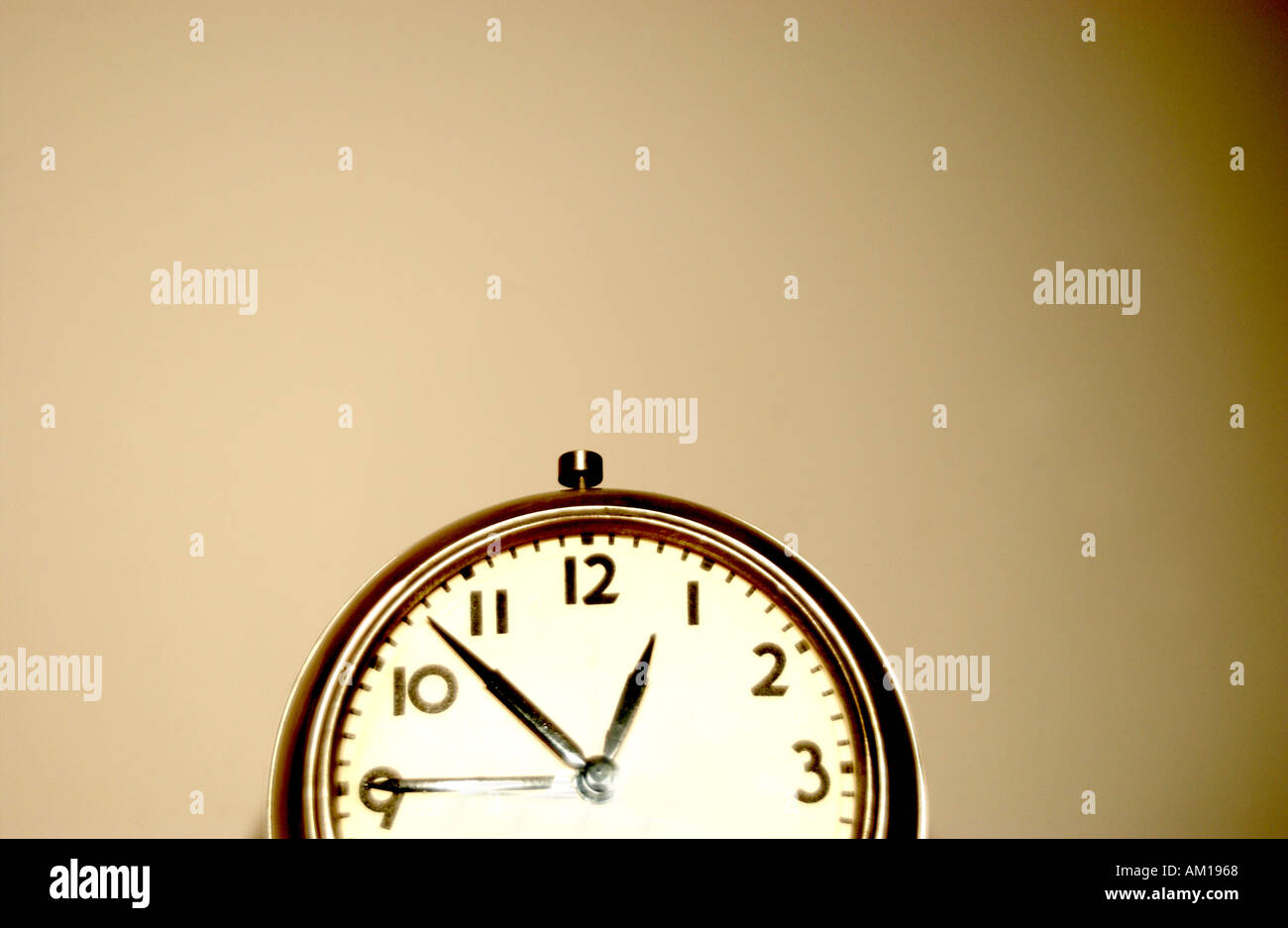 Horizontal abstract color image of clock sitting against a plain wall ...
