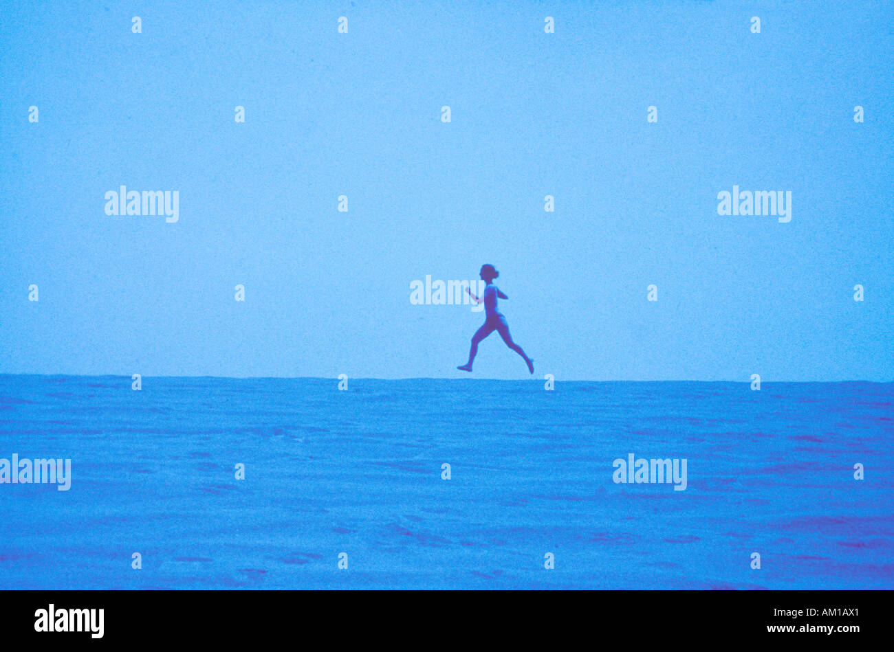 Silhouette of runner on beach Stock Photo - Alamy