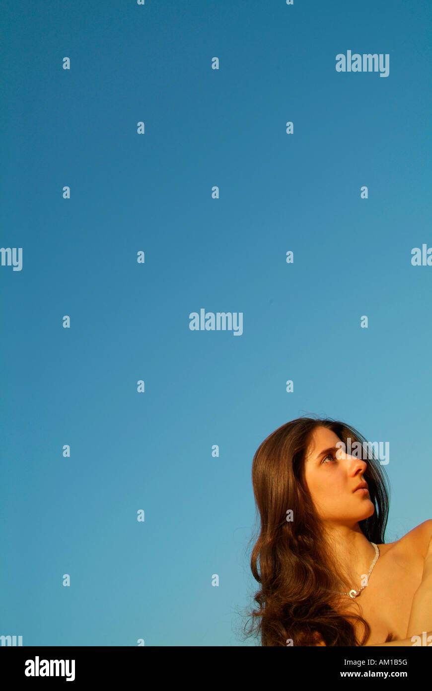 Portrait of woman in front of blue sky Stock Photo - Alamy
