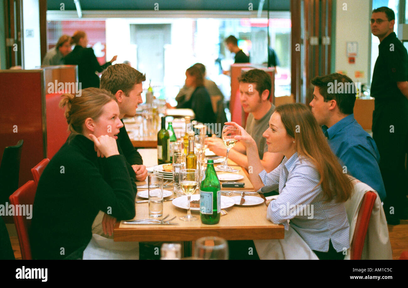 Group eating in restaurant girls chatting dinner pizza drinking ...