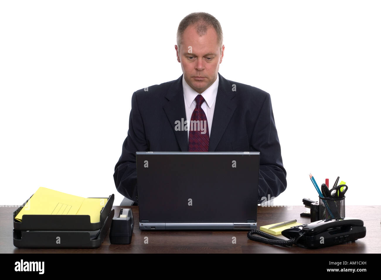 Businessman sat at his desk using a laptop computer Stock Photo - Alamy