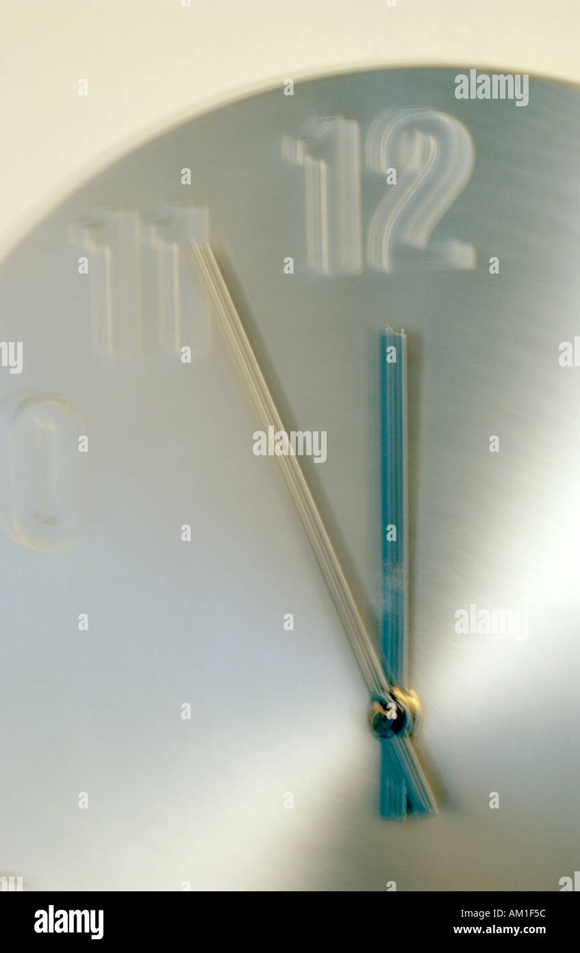 Vertical color image of a brushed metal clock showing blurred numbers ...