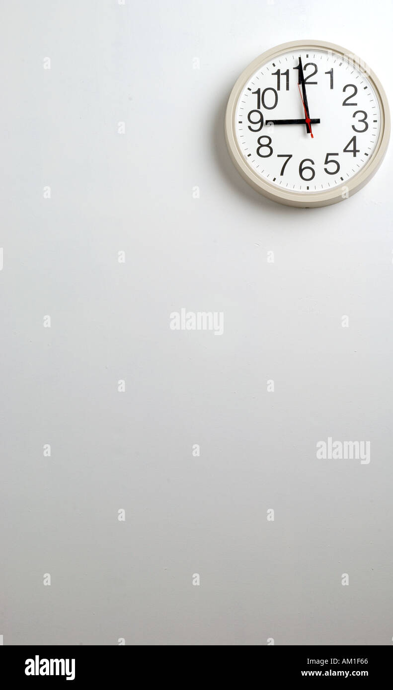 Vertical color image of a clock on a white wall Stock Photo - Alamy