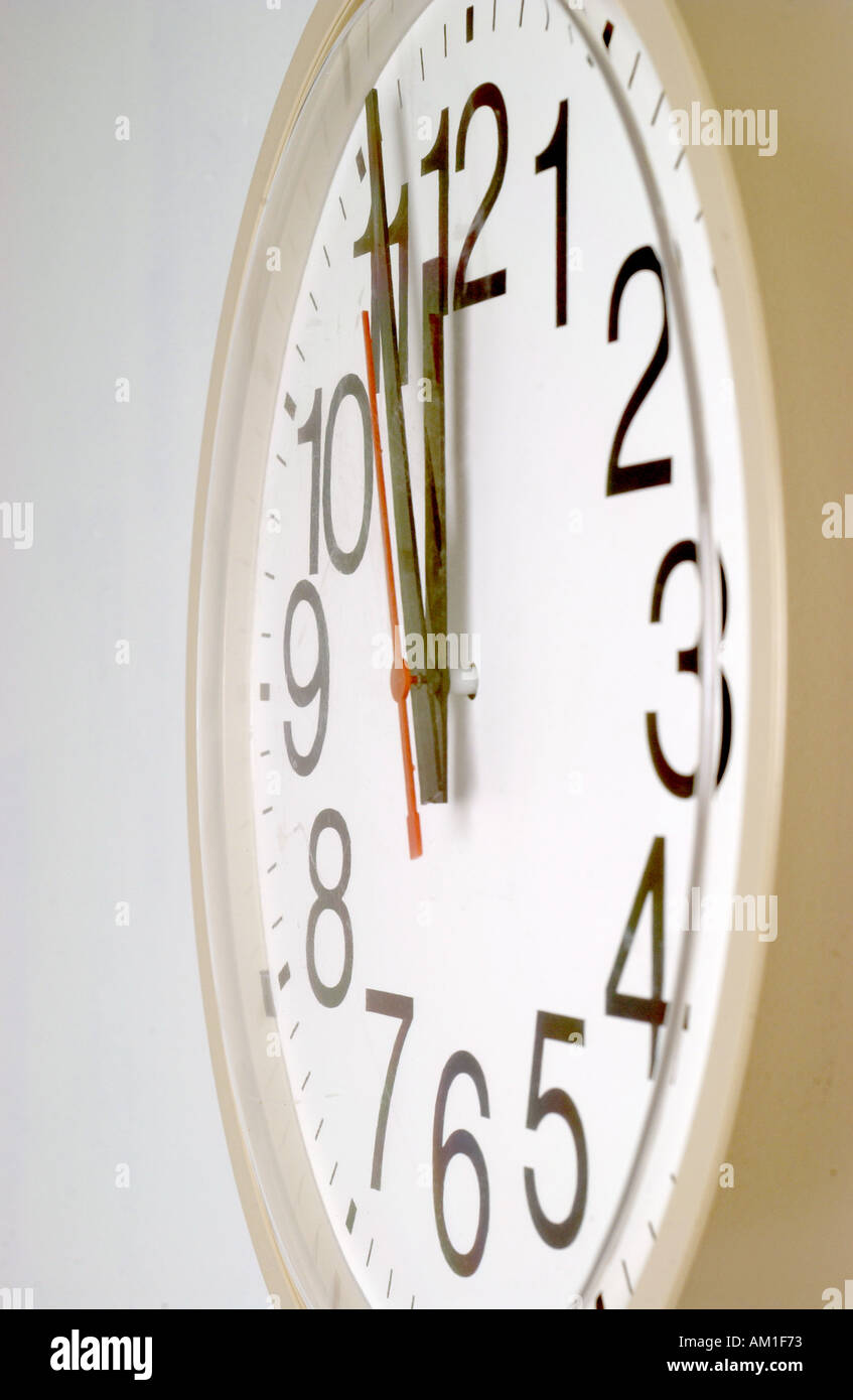 Vertical color image of a clock mounted on a white wall viewed from a ...