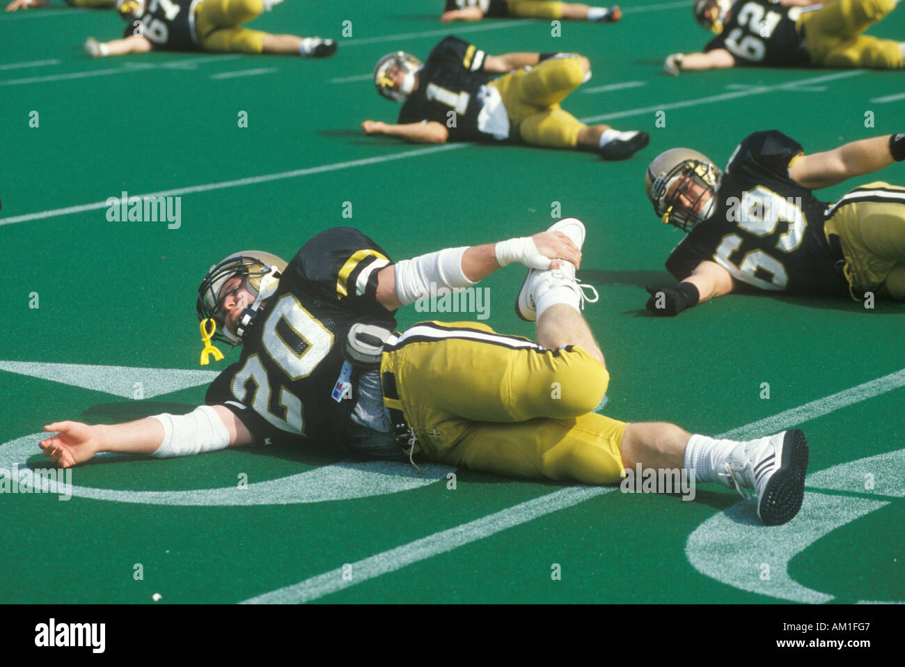 Football players warming up with stretches on field prior to Game ...