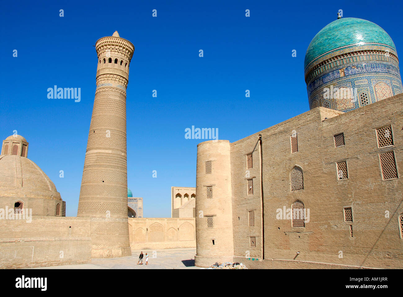 High brick tower Minaret Kalon with blue decorated cupola of Mir-i Arab Madrasah Bukhara ...