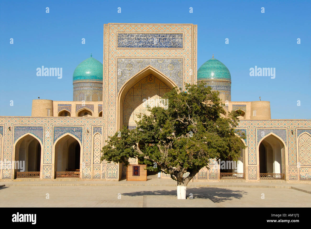Tree in front of rich decorated iwan inside Mosque Kalon Bukhara ...