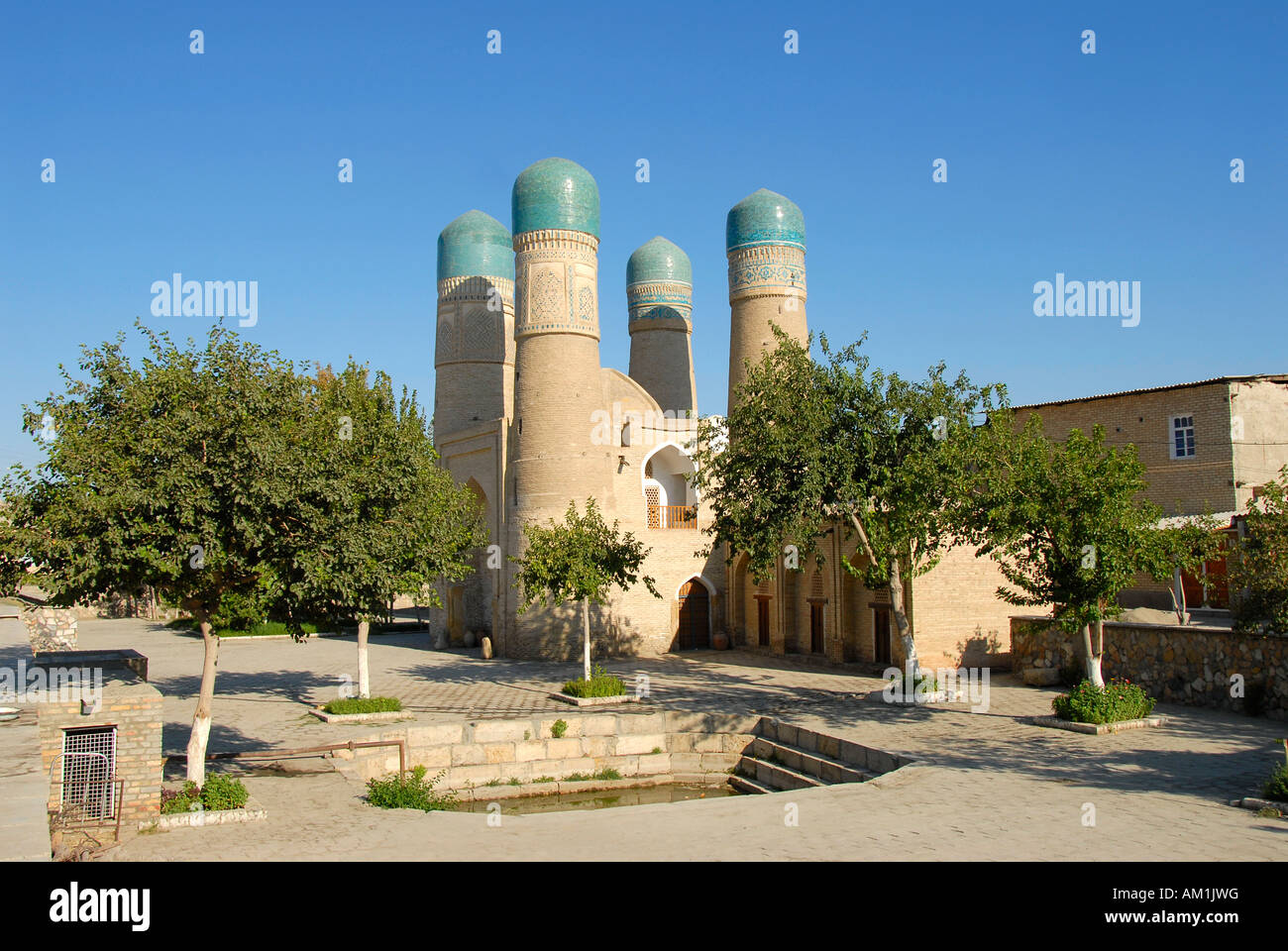 Four minarets Char Minar gatehouse behind trees Bukhara Uzbekistan ...