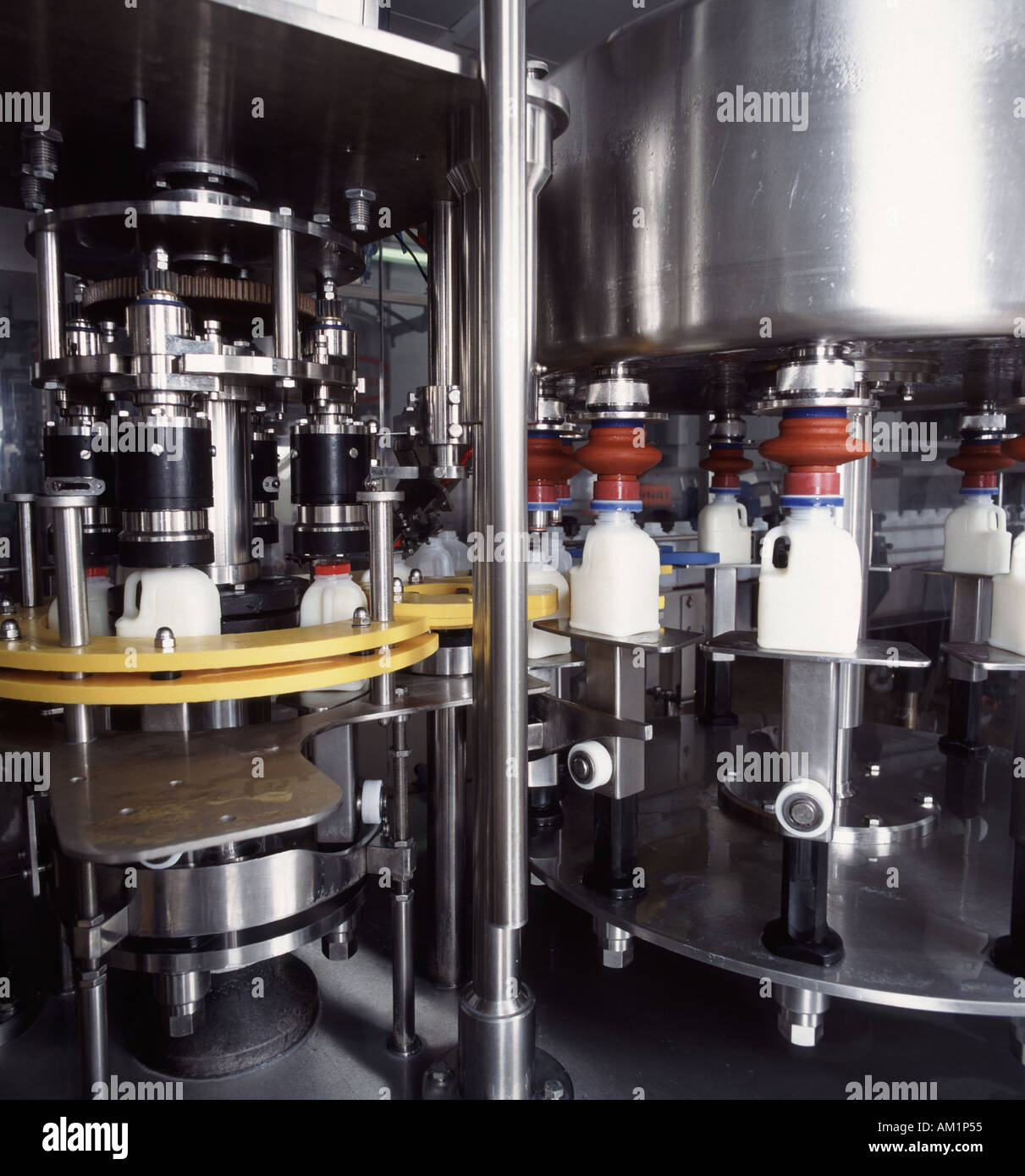 Milk on automated production line being bottled into plastic containers ...