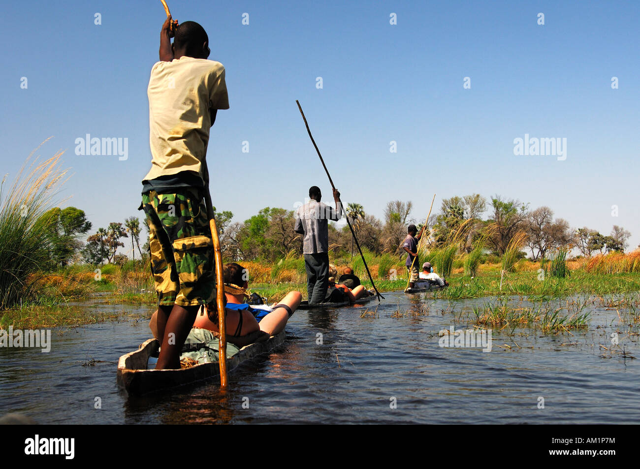 Locals in Mokoro dugoutboat on a tourist excursion in the Okavango ...