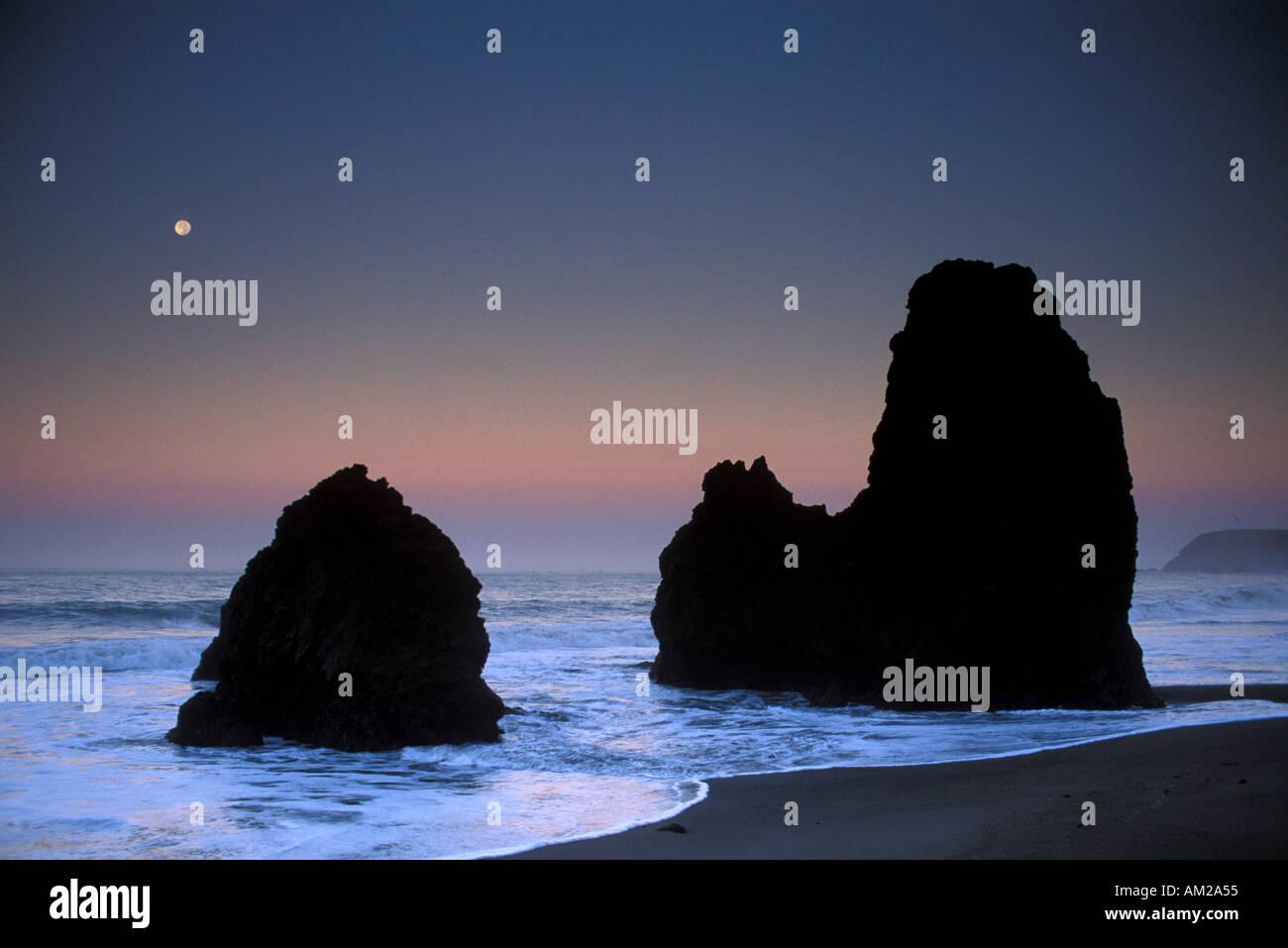 Full Moon setting at dawn over Pacific Ocean and coastal sea stacks at ...