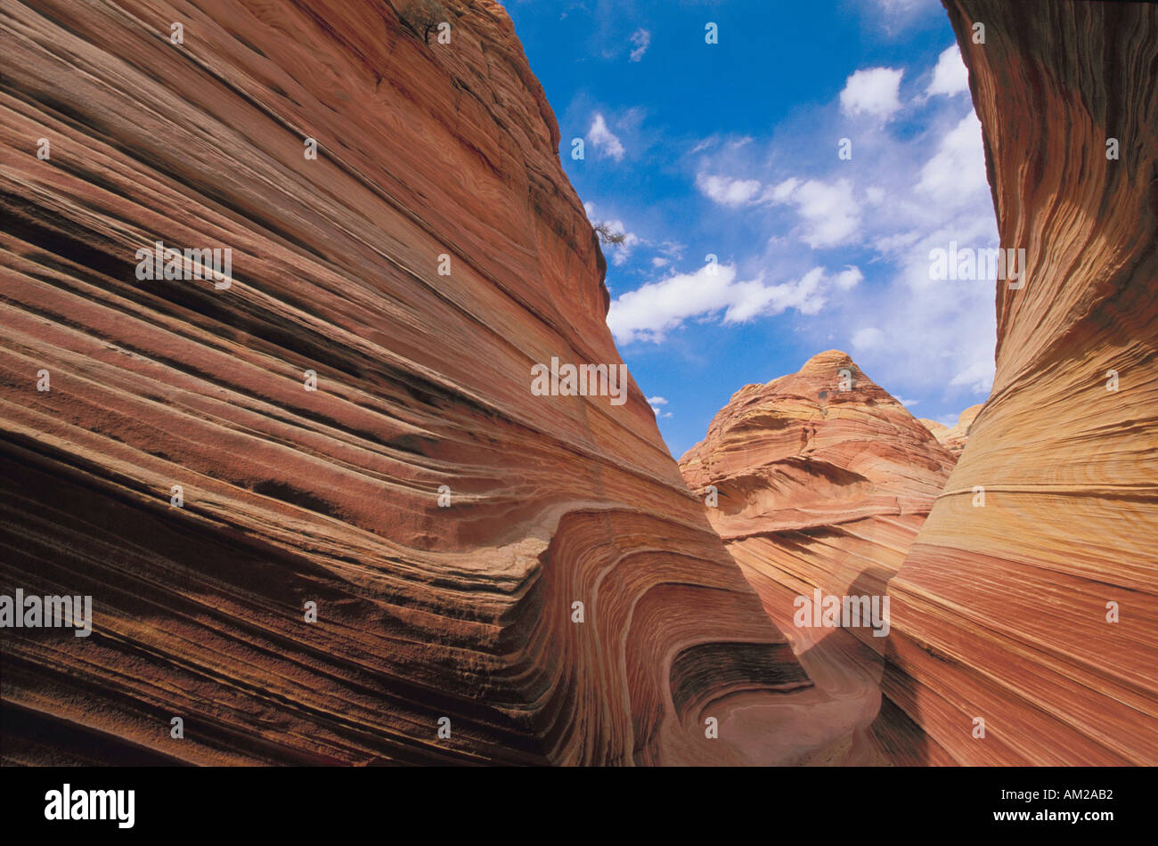 red layered sandstone formation narrow walls spire blue sky clouds The ...