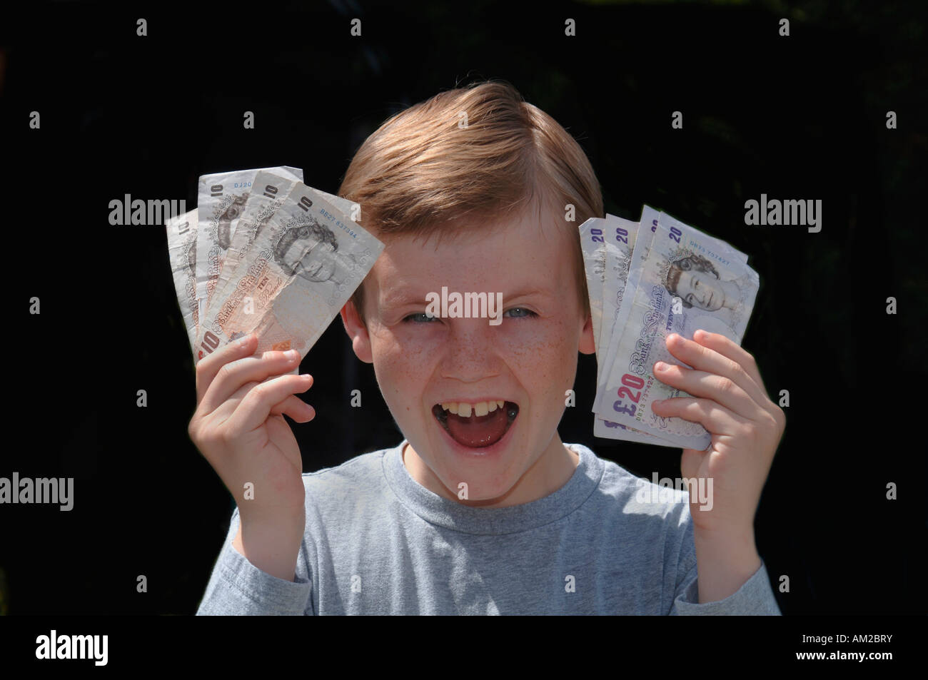 A 12 Year Old Boy Holding 20 &10 Pound English Bank Notes Stock Photo ...