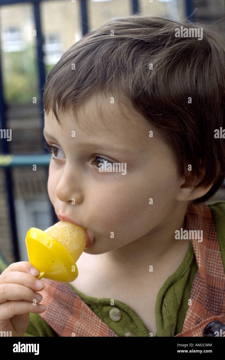 3 year old girl eating an icicle Stock Photo - Alamy