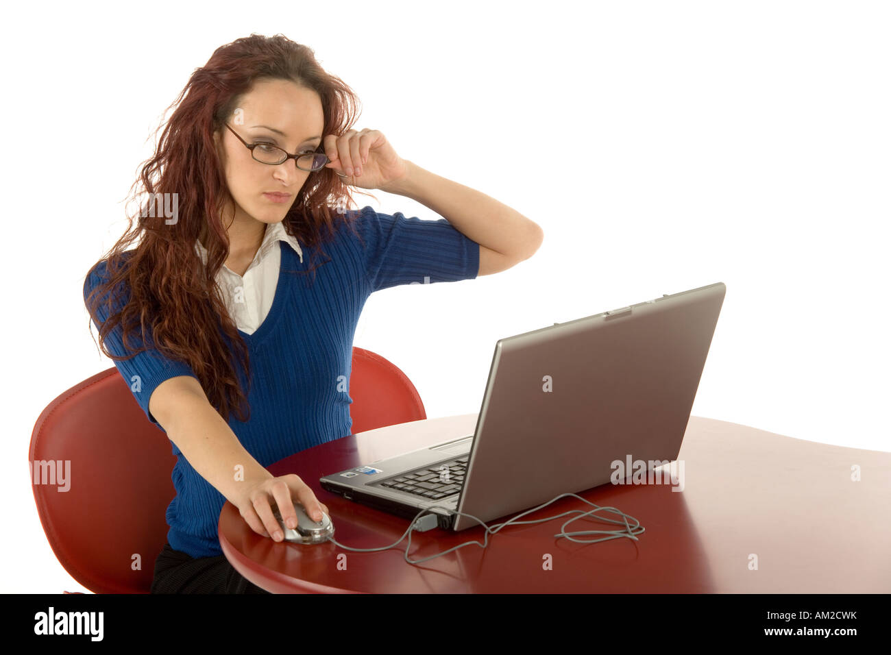 Young woman working on a laptop computer against a white background ...