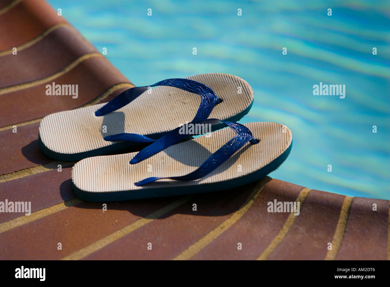 Flip flops on the side of a pool Stock Photo - Alamy