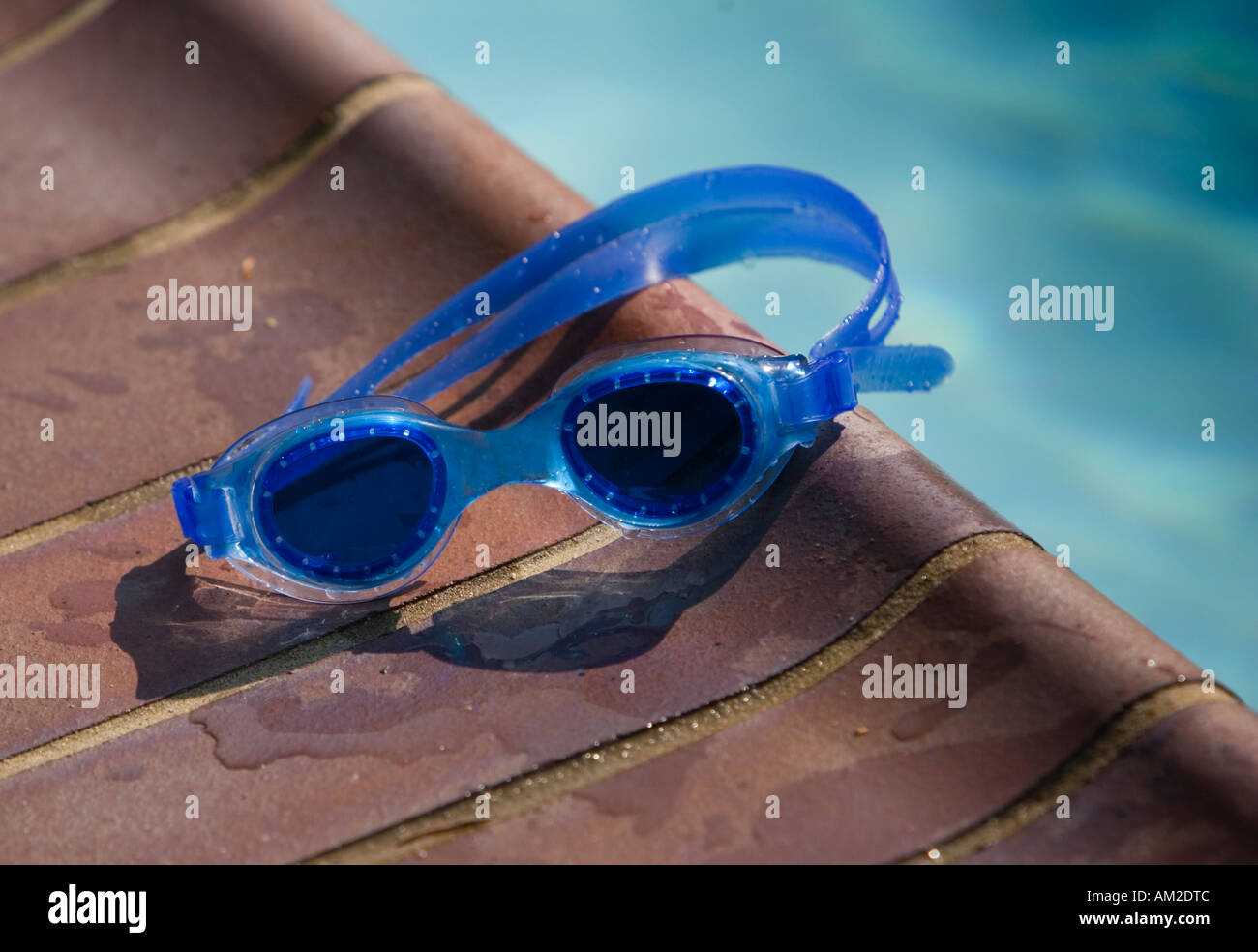 Pair of swim goggles by the side of a pool Stock Photo - Alamy