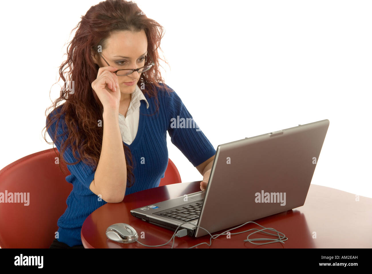 Young woman working on a laptop computer against a white background ...